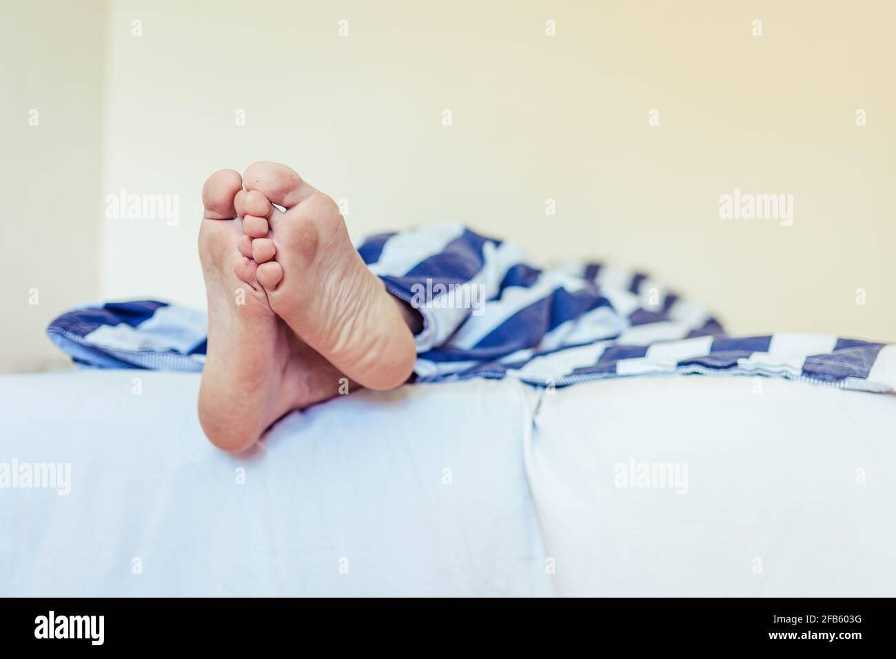 Closeup shot of a male sleeping in the bad, man feet Stock Photo - Alamy