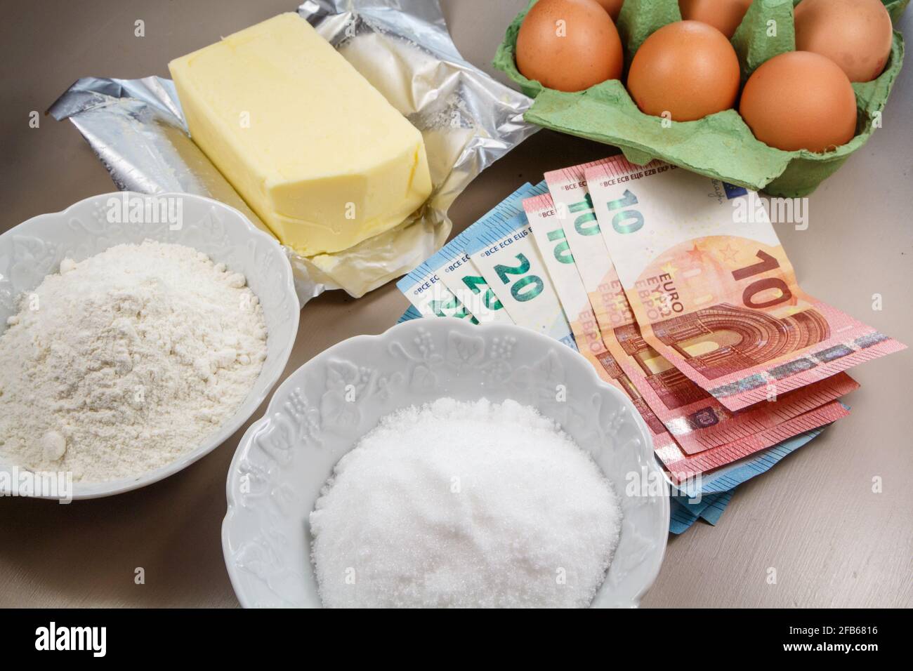 Ingredients to make a cake and banknotes of ten and twenty euros as ...