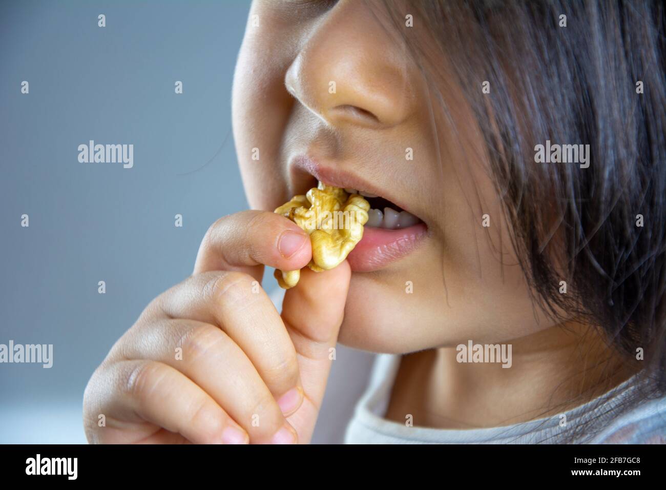 Little girl tasting walnuts in close-up Stock Photo - Alamy