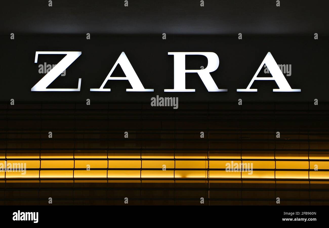 Lit white Zara shop sign before opening with metal shutters Stock Photo ...