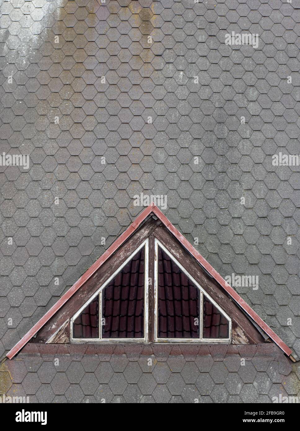 An older triangular window on the roof of the house Stock Photo - Alamy