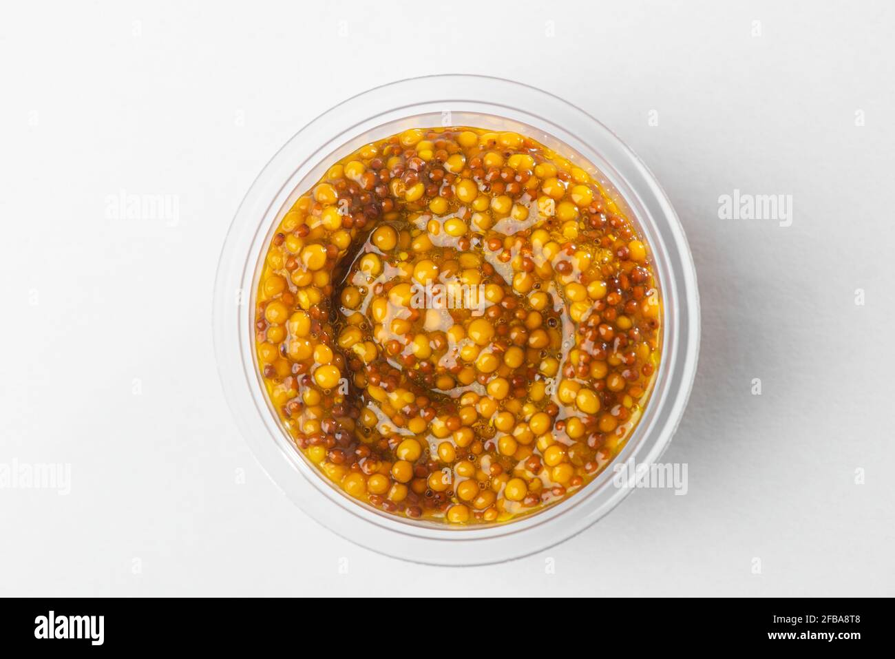 Top view on a cup of whole grain mustard on white background Stock ...