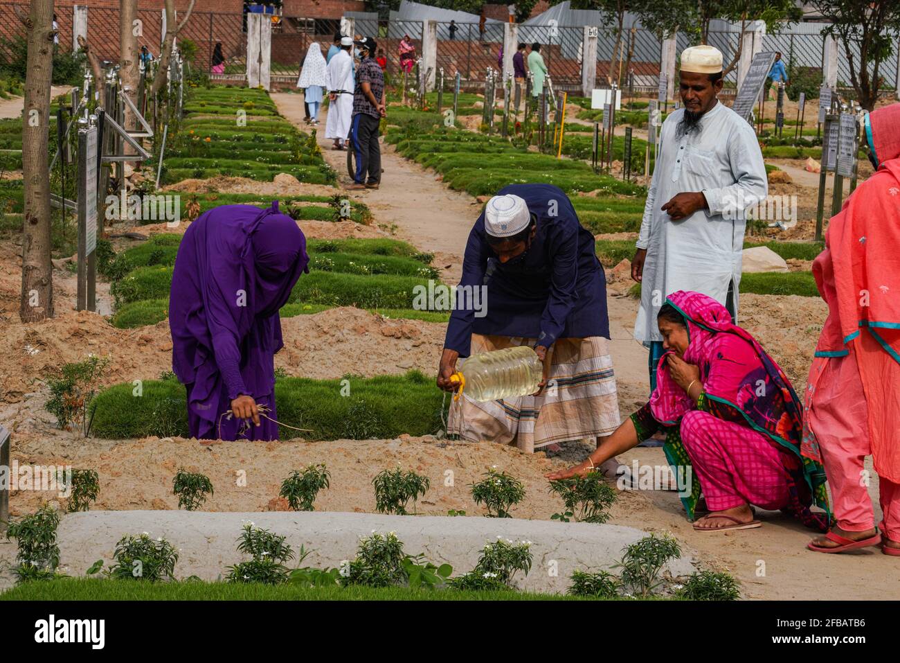 Family member saying a prayer for their relative, a COVID-19 deceased ...