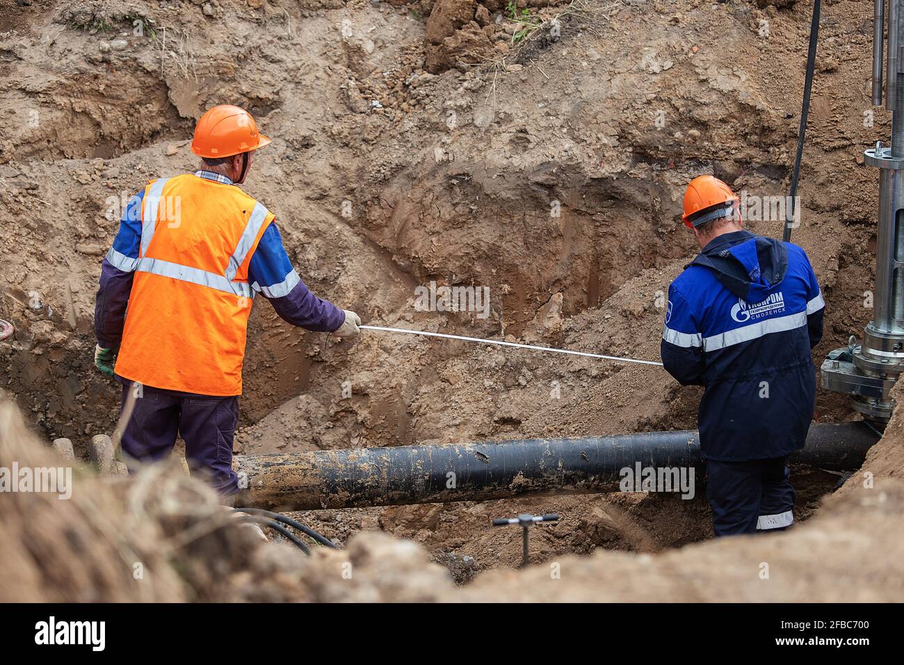 a man working in uniform is engaged in repairing the gas pipe ...