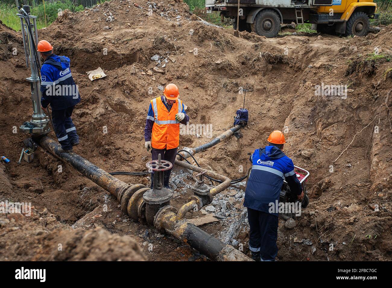 a man working in uniform is engaged in repairing the gas pipe ...
