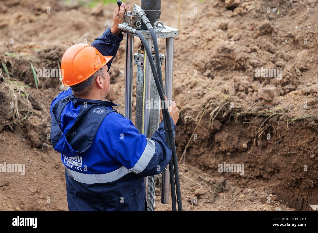 a man working in uniform is engaged in repairing the gas pipe ...