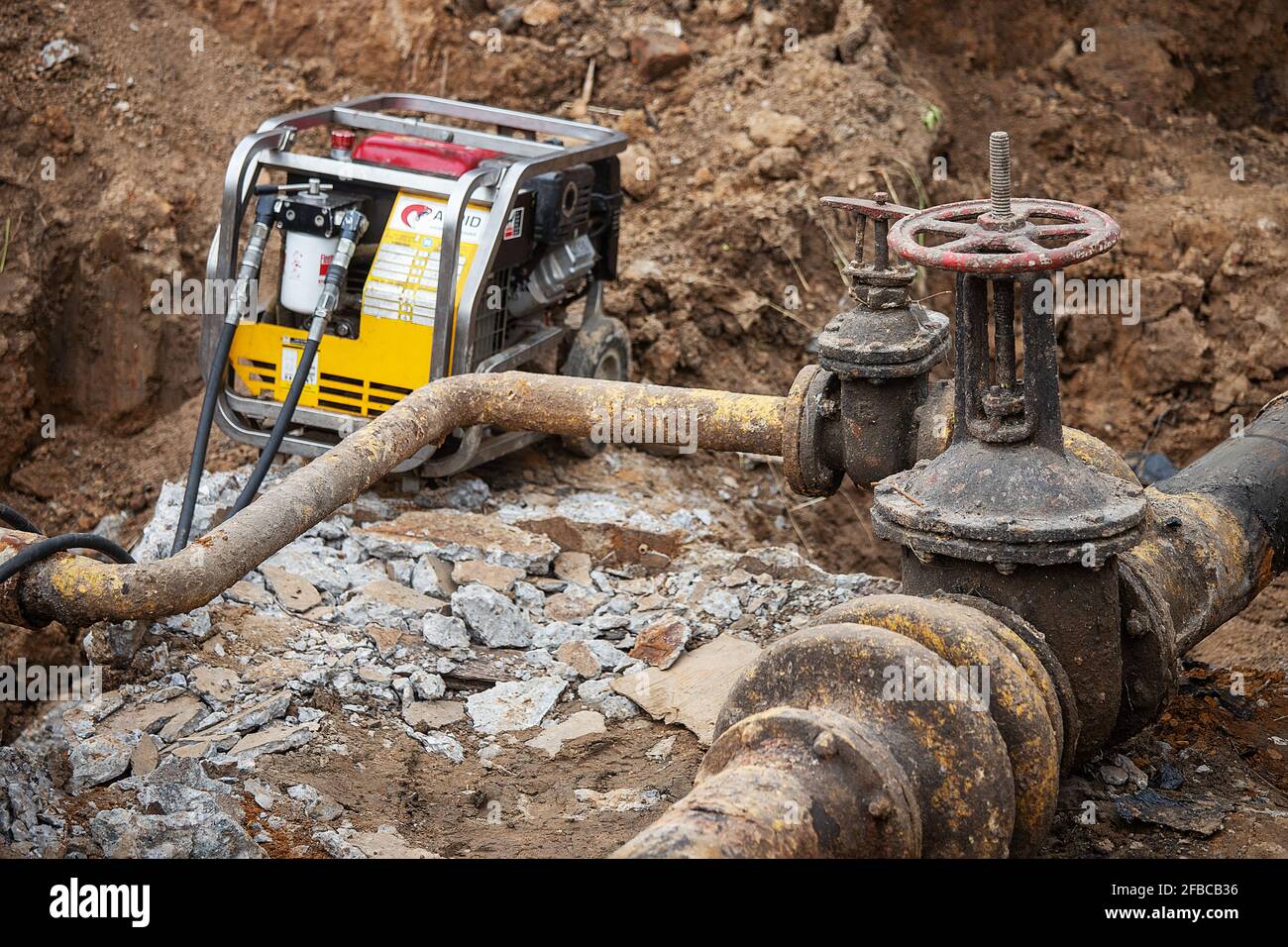 a man working in uniform is engaged in repairing the gas pipe ...
