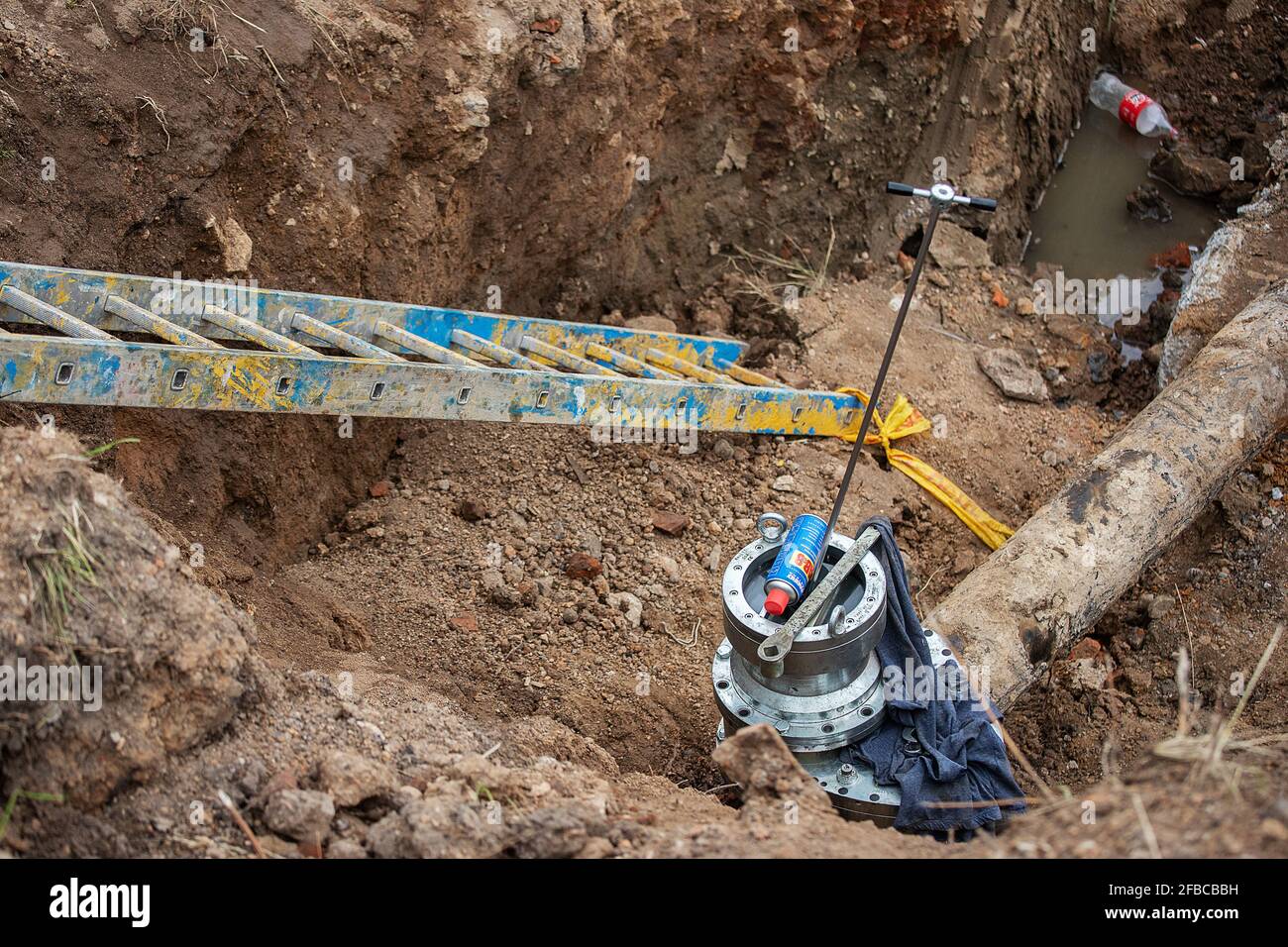 a man working in uniform is engaged in repairing the gas pipe ...