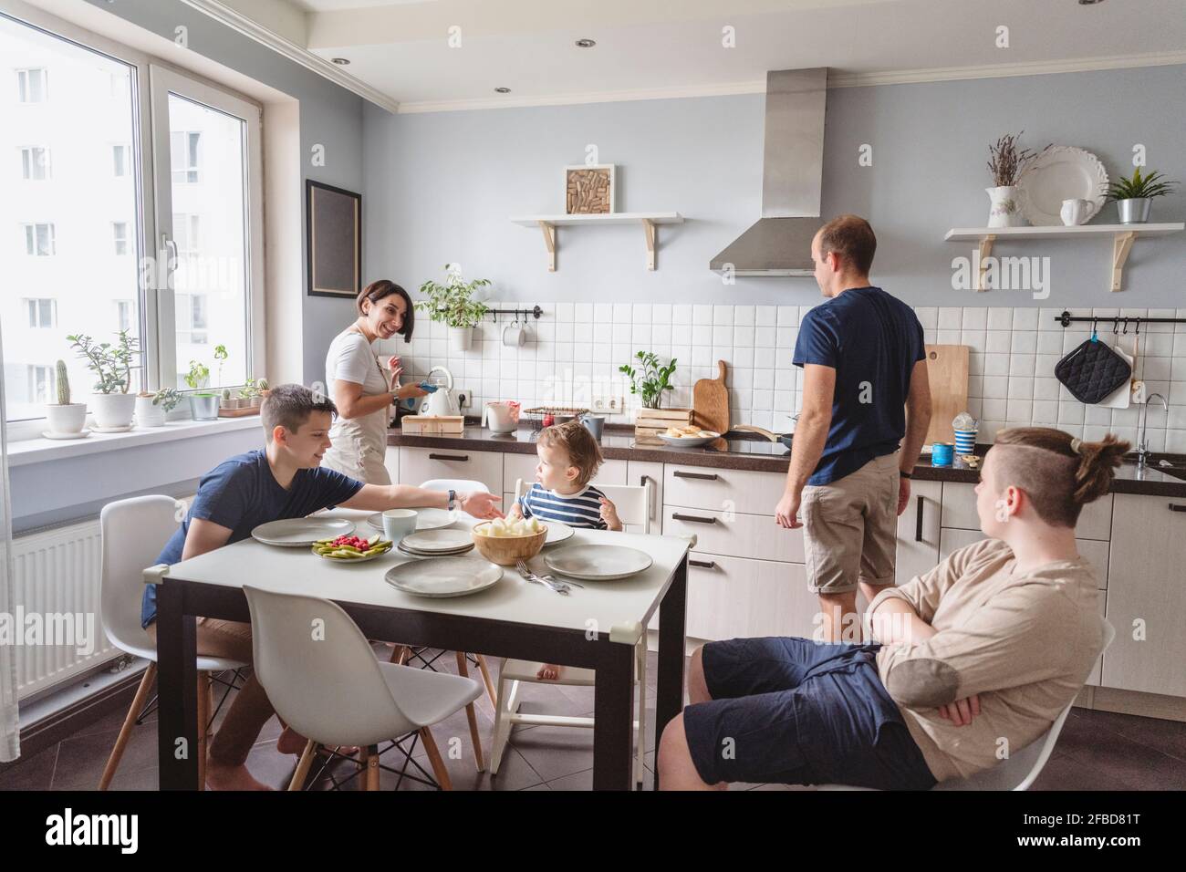 Happy family in kitchen at home Stock Photo - Alamy