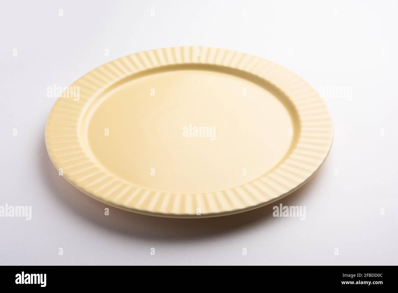 Empty yellow ceramic round plate with decorative border isolated on ...