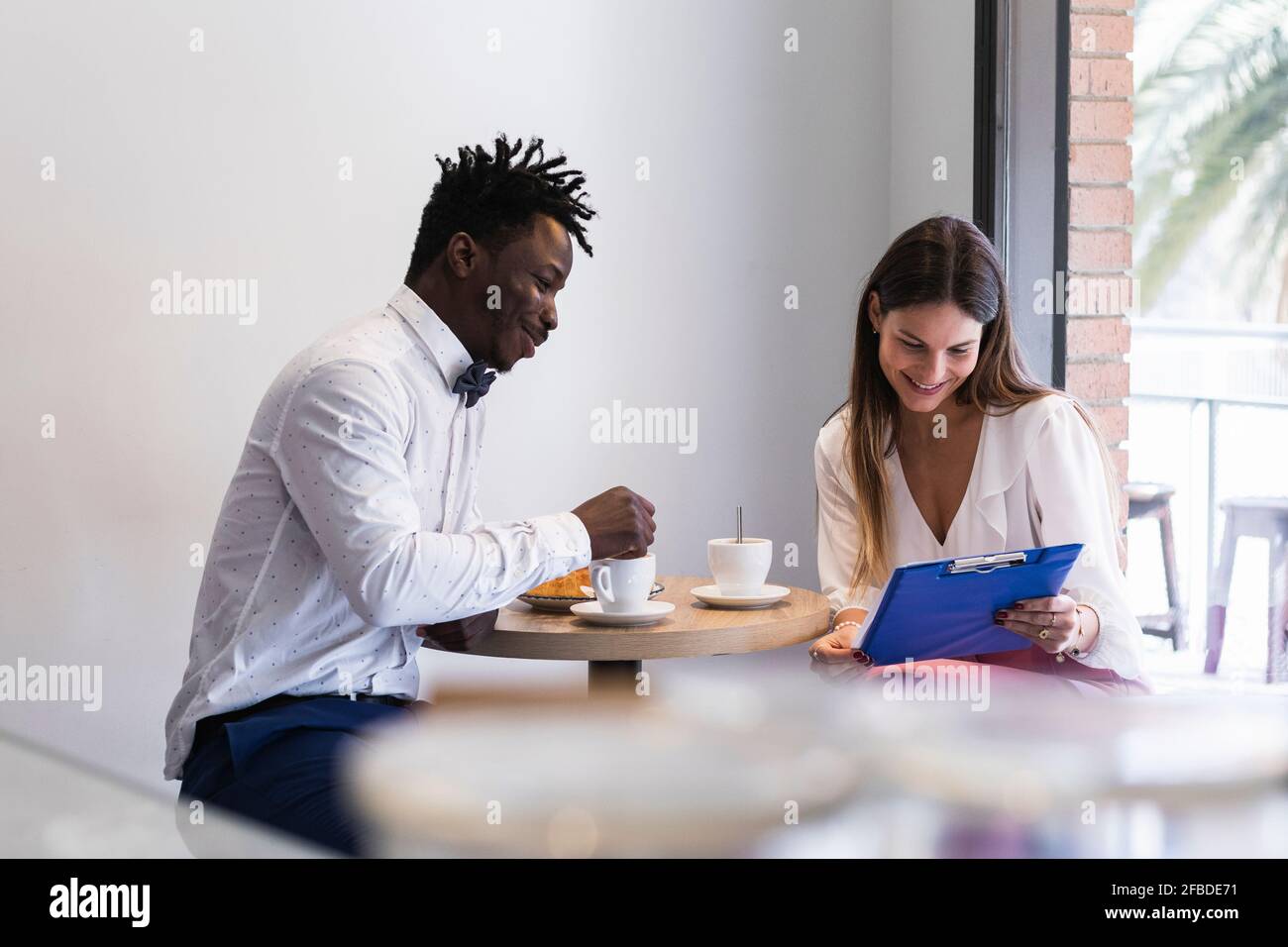 Smiling business people working while having coffee at cafe Stock Photo ...