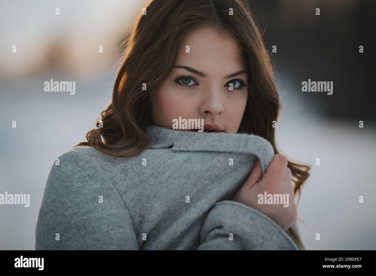 Beautiful Caucasian woman in a winter coat feeling cold during snow ...
