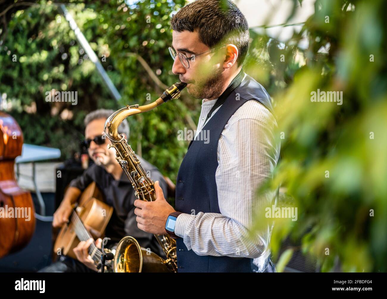 Man playing saxophone while performing at event Stock Photo - Alamy
