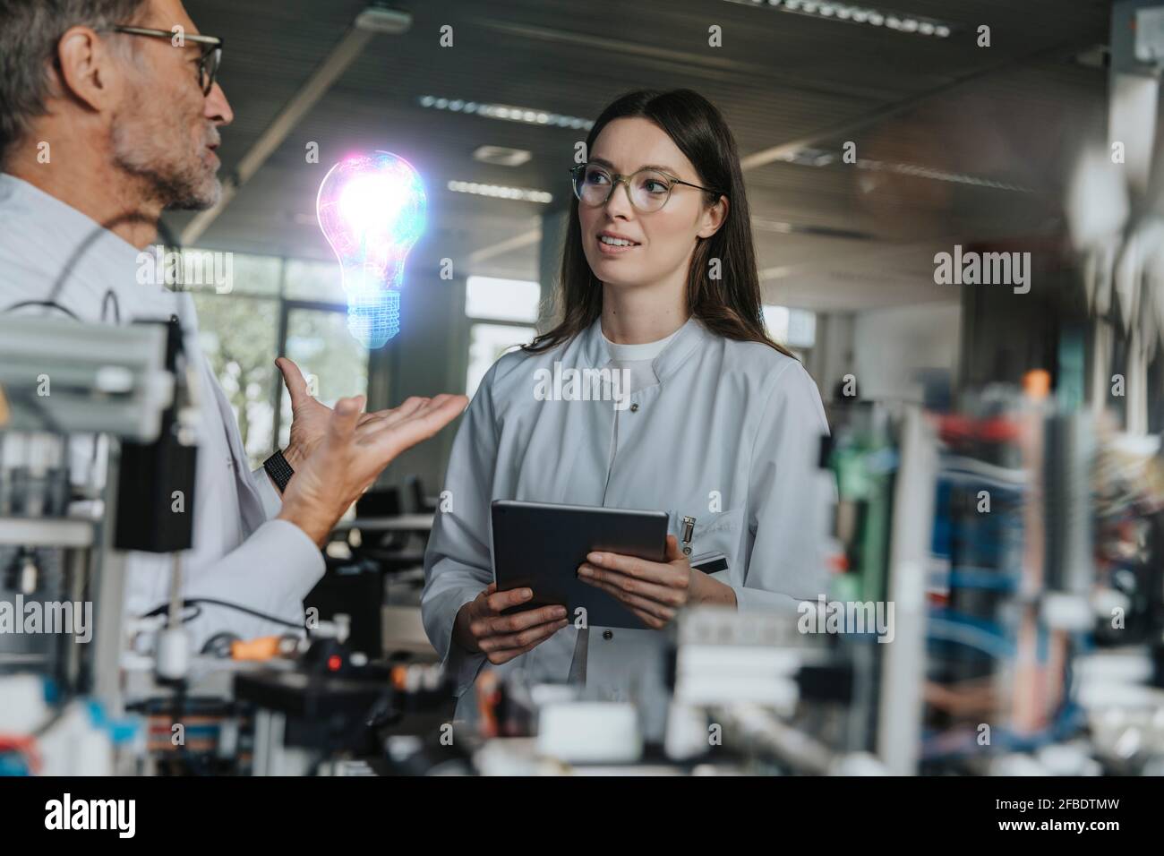 Male engineer discussing with female colleague in industry Stock Photo ...
