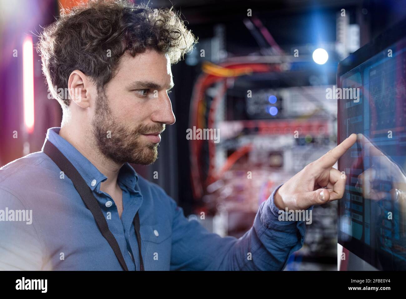 Male IT professional touching computer screen in data center Stock ...