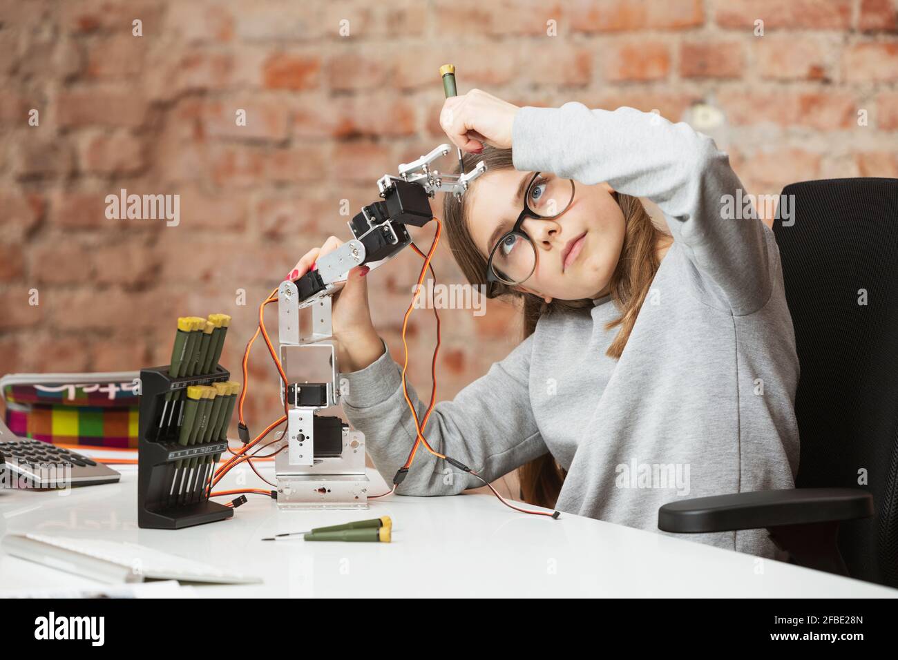 Girl doing scientific experiment on robotic arm at table Stock Photo ...