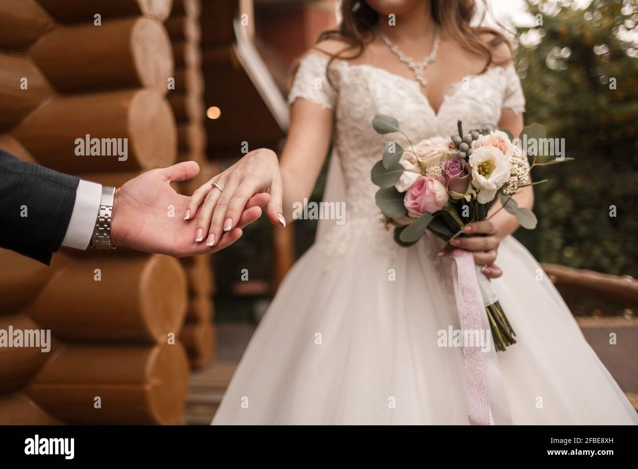 Wedding bouquet with fresh natural flowers in the hands of the bride ...