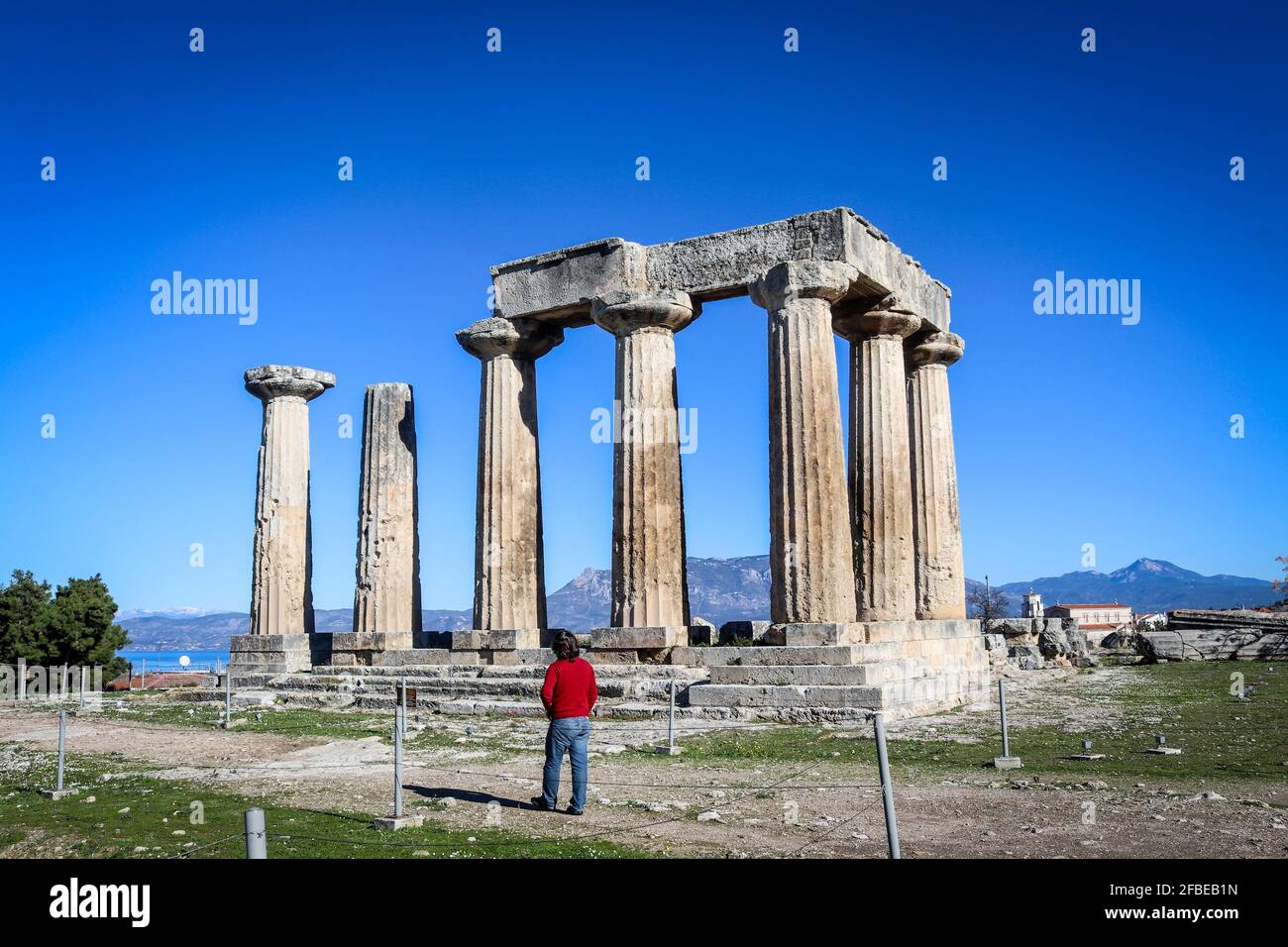 Ancient Corinth Greece - Ruins of Temple of Apollo with tourist walking ...