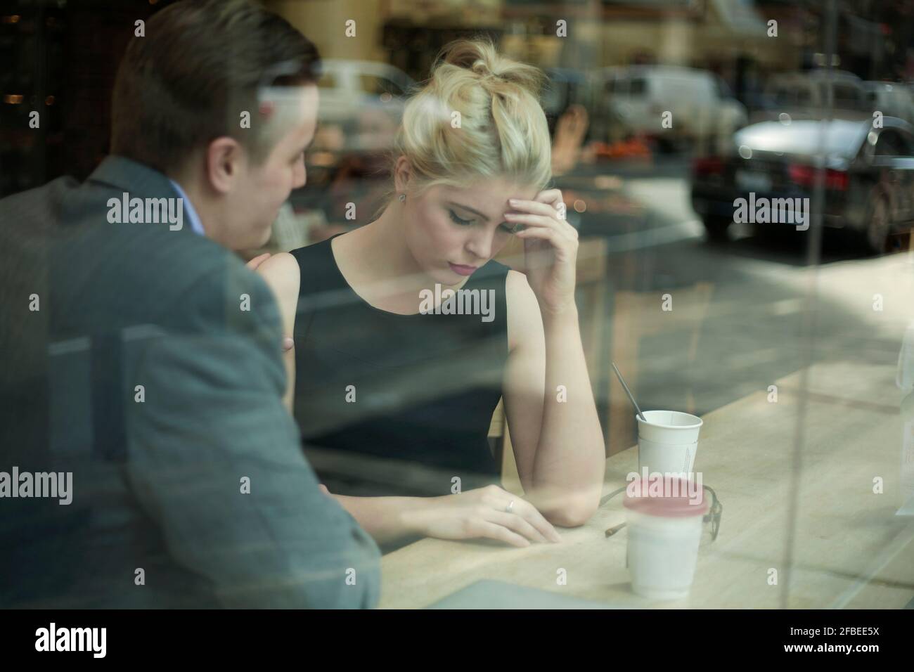 Businessman consoling sad female colleague in cafe Stock Photo - Alamy