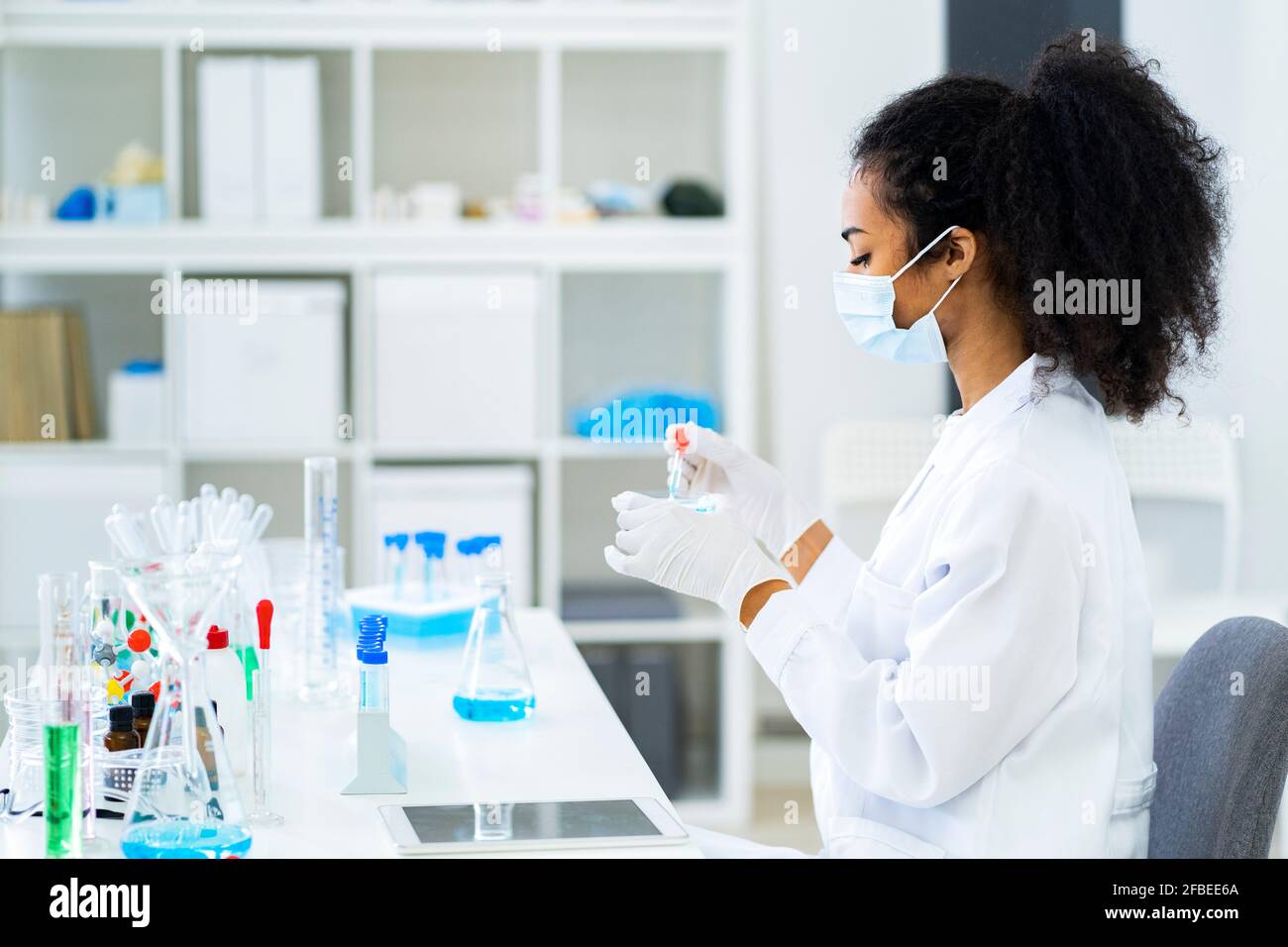 Young researcher doing scientific experiment in laboratory during ...