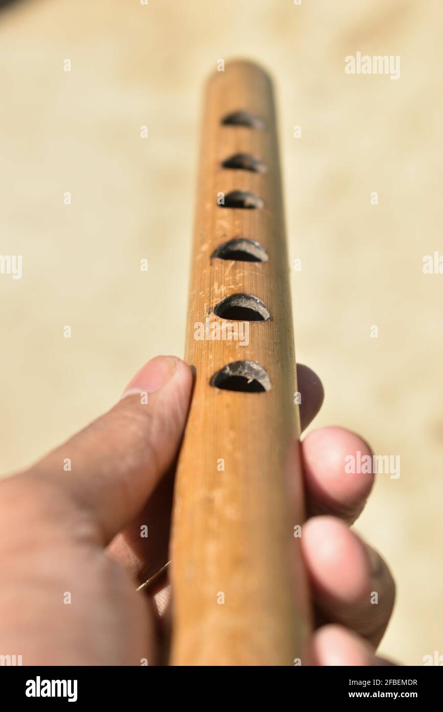 Vertical of a hand holding wooden flute Stock Photo - Alamy