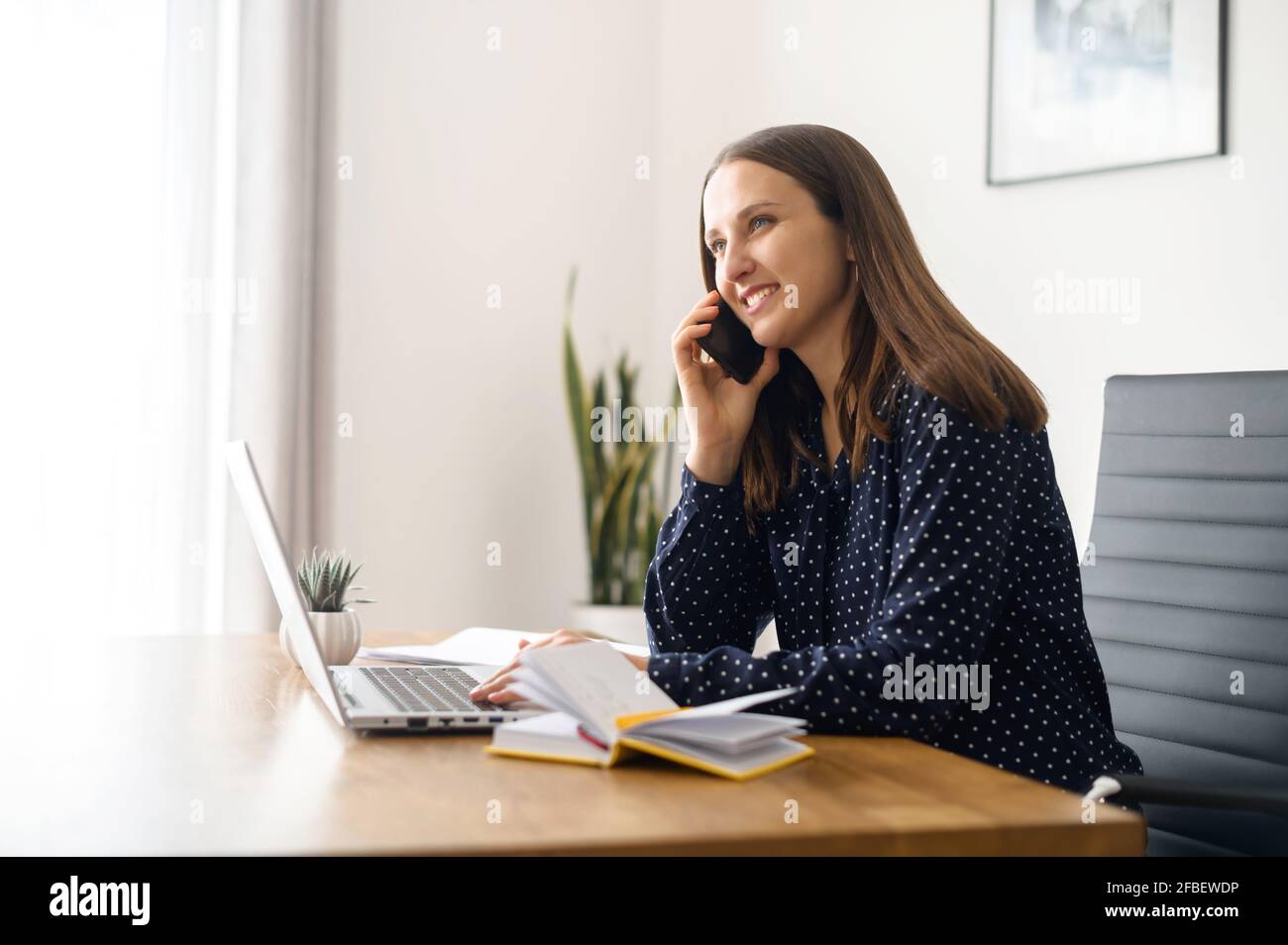 Executive female office employee takes a phone call sitting on the ...