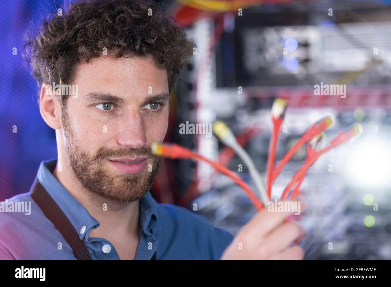 Male IT technician looking at patch cord cables in data center Stock ...