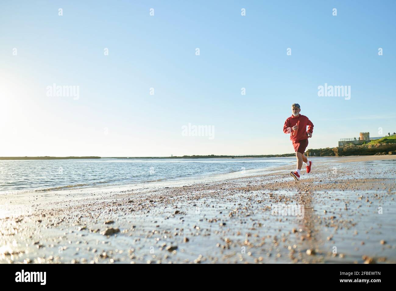 Man running on beach at sunset hi-res stock photography and images - Alamy