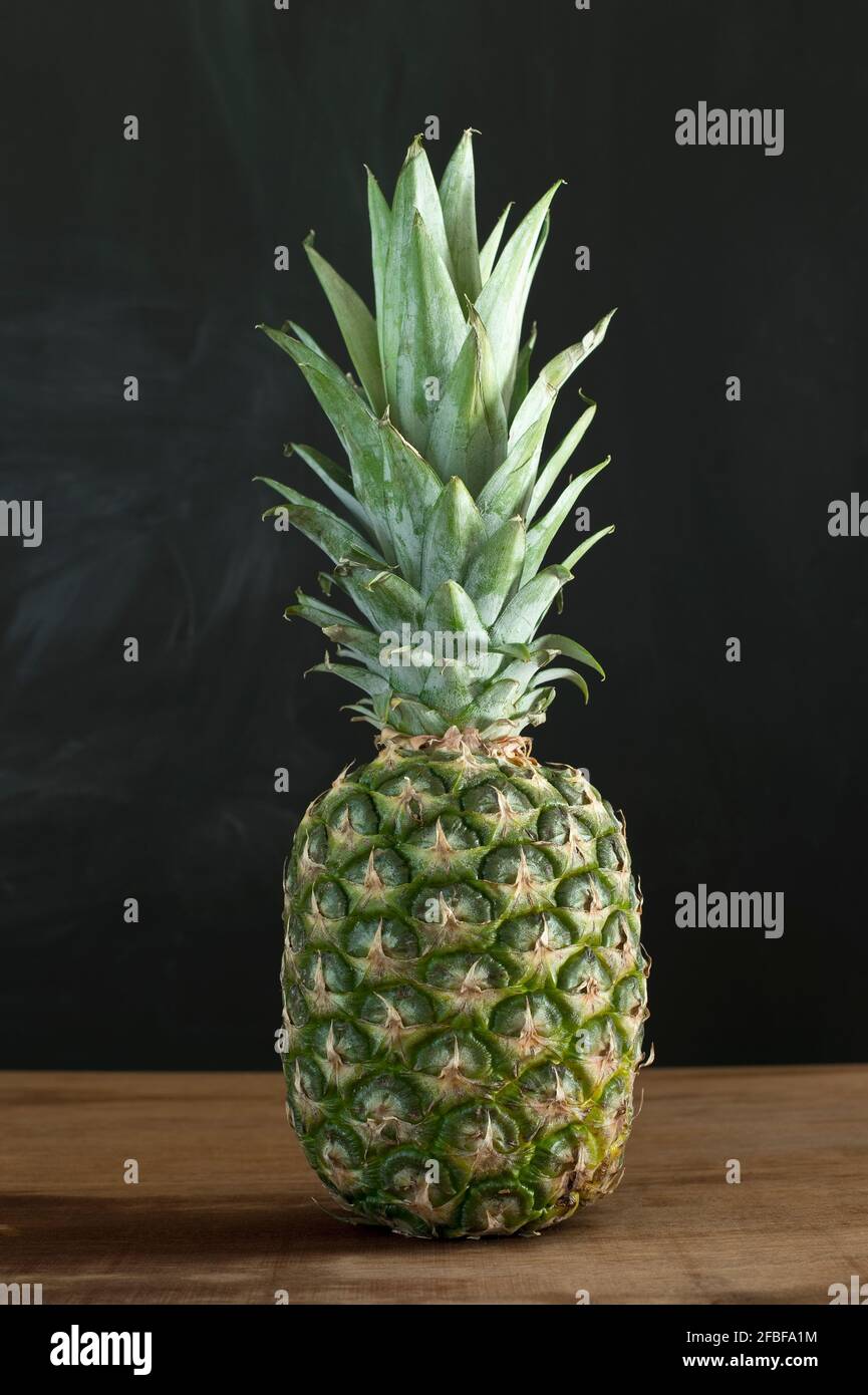 Still life with pineapple in front of dark wall Stock Photo - Alamy