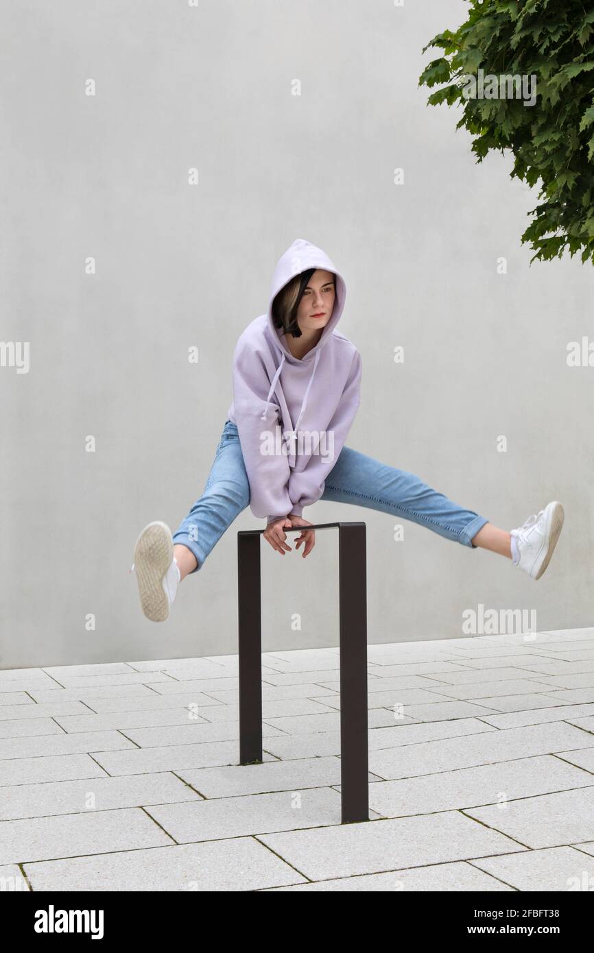 Girl jumping over metal by wall Stock Photo - Alamy