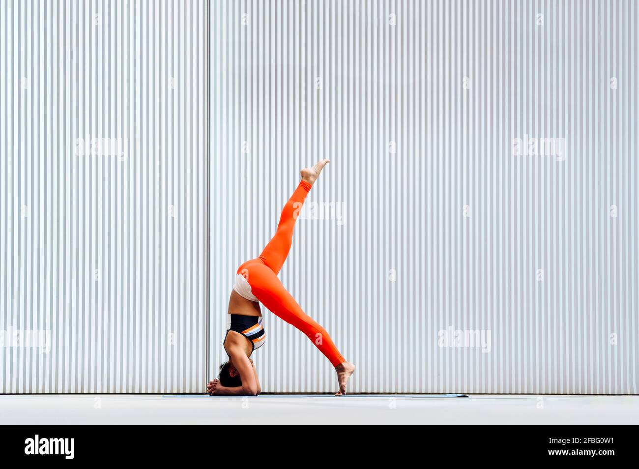 Female athlete doing headstand by wall Stock Photo - Alamy