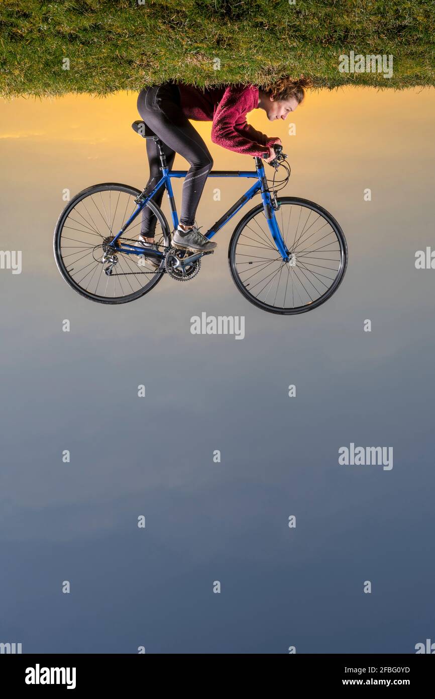 Upside down image of woman with bicycle lying on grass Stock Photo - Alamy