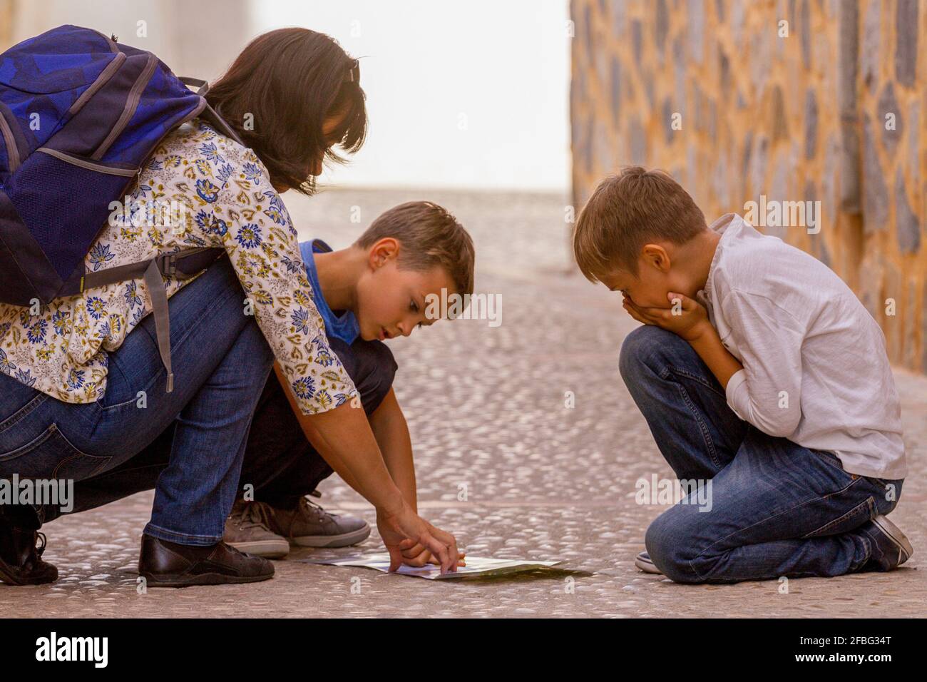Mother with two kids looking at paper map to find destination in the ...