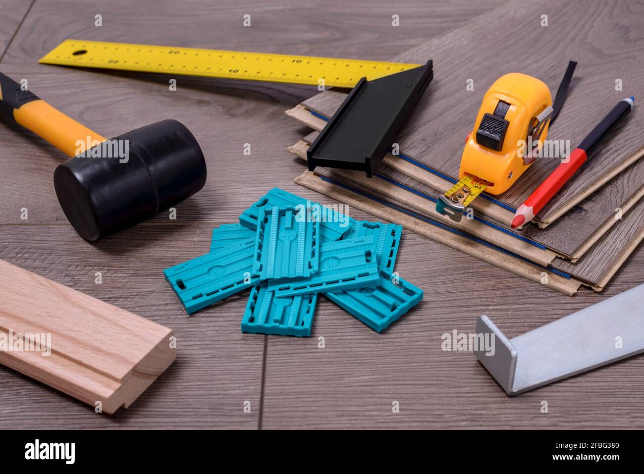 Planks of laminate floor and equipment or tools to install them, hammer ...