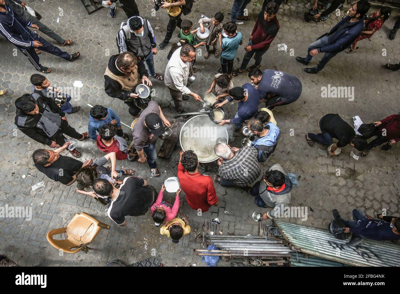 Palestinian Walid Al-Hattab (wearing a plaid shirt) distributes free ...