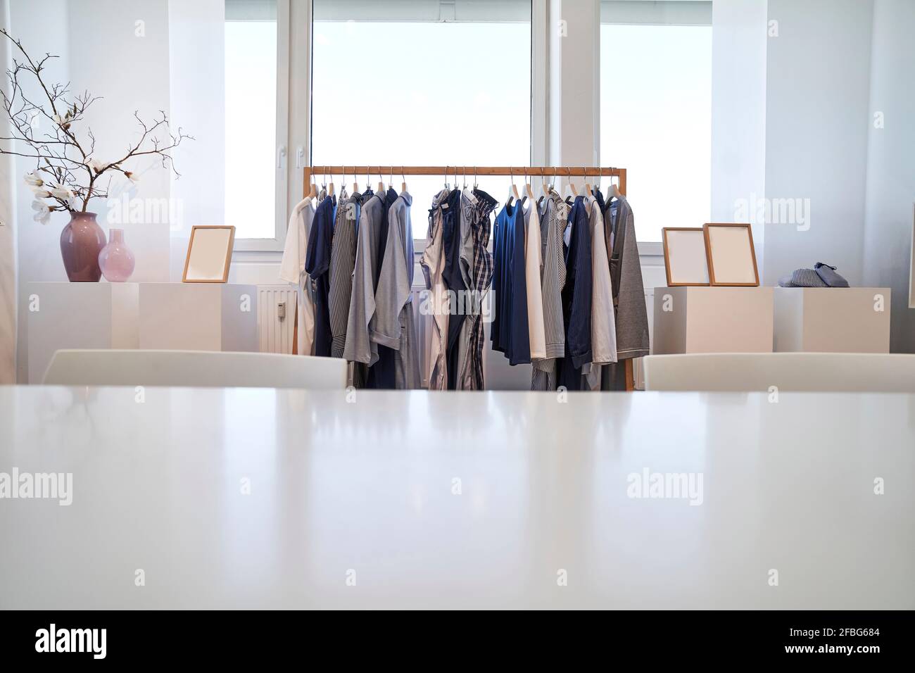Garments hanging on rack in clothes design studio Stock Photo - Alamy