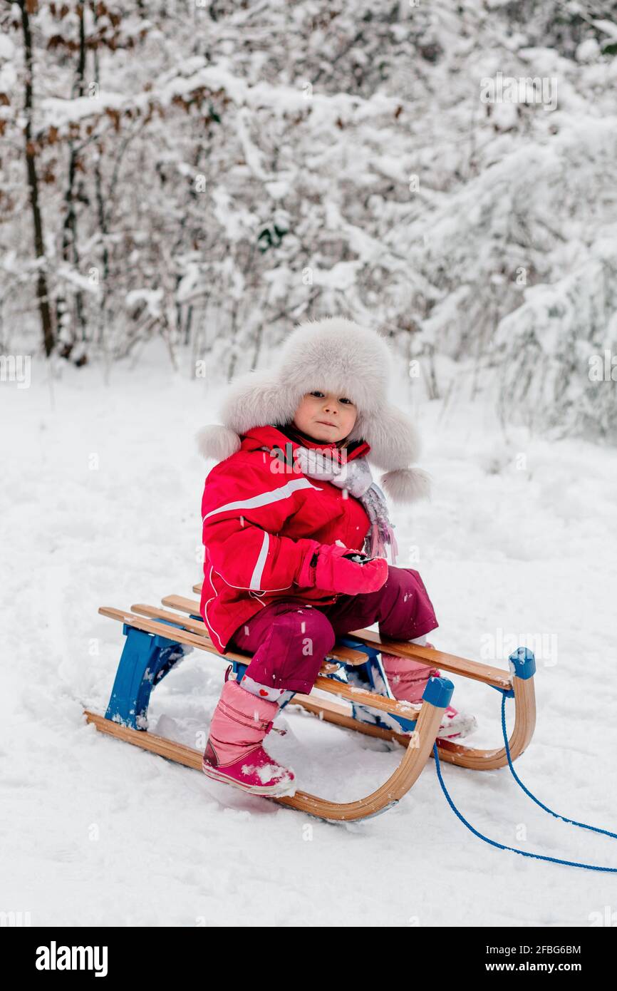 Girl sitting on a sledge Stock Photo - Alamy