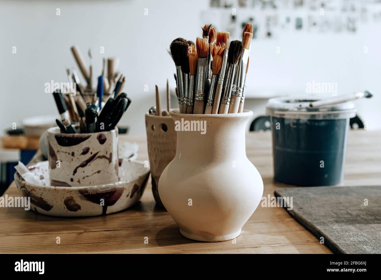 Ceramic utensils with brushes and other artisan tools on the table in ...