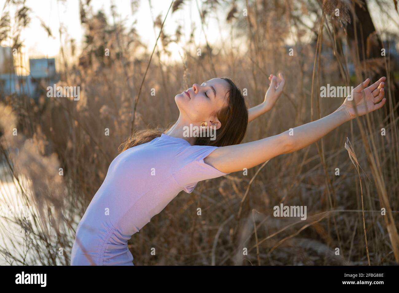 Young woman with arms raised dancing in nature Stock Photo - Alamy