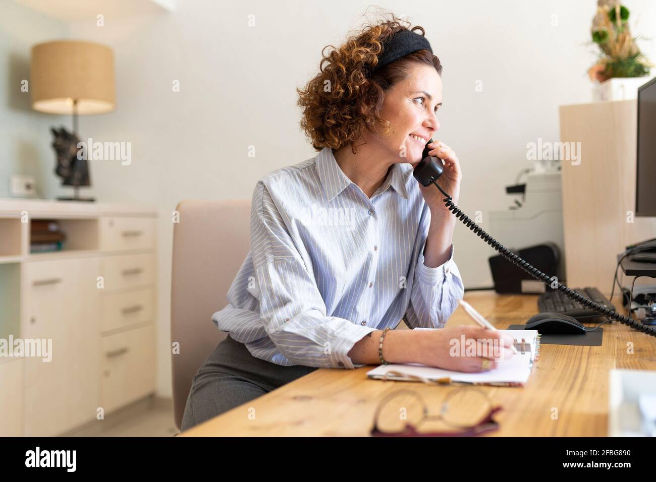 Female hotel receptionist talking on telephone hi-res stock photography ...