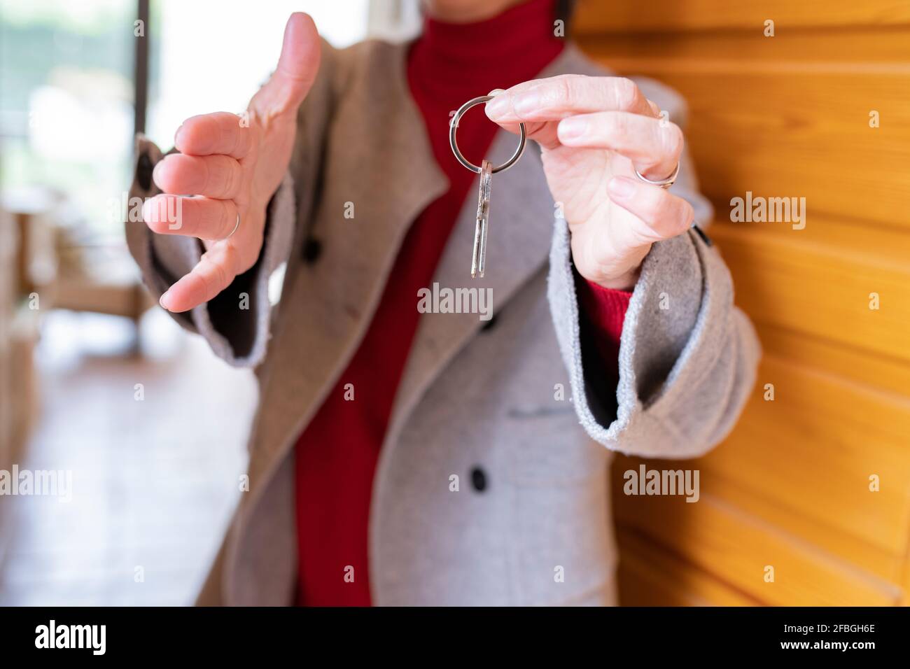 Woman offering handshake while holding house key at front door Stock ...