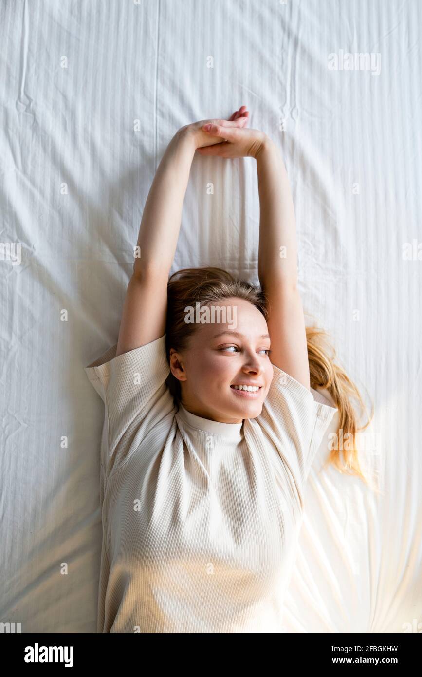 Woman lying on bed stretching hi-res stock photography and images - Alamy