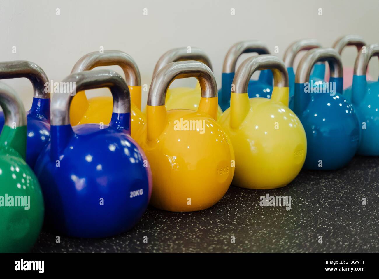 Multi colored kettlebell in a line at gym Stock Photo - Alamy