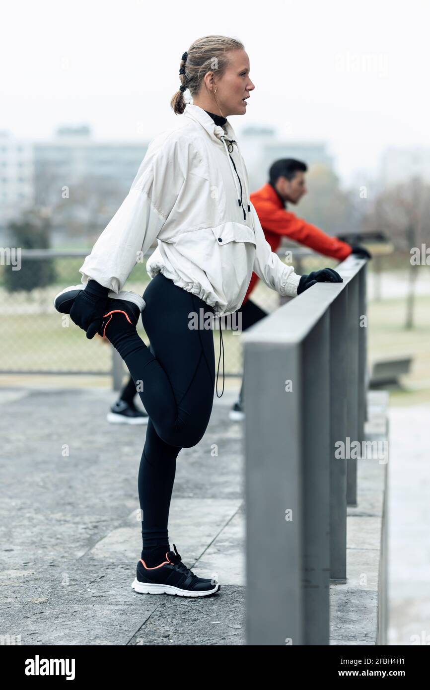 Sportive woman stretching leg fence hi-res stock photography and images ...