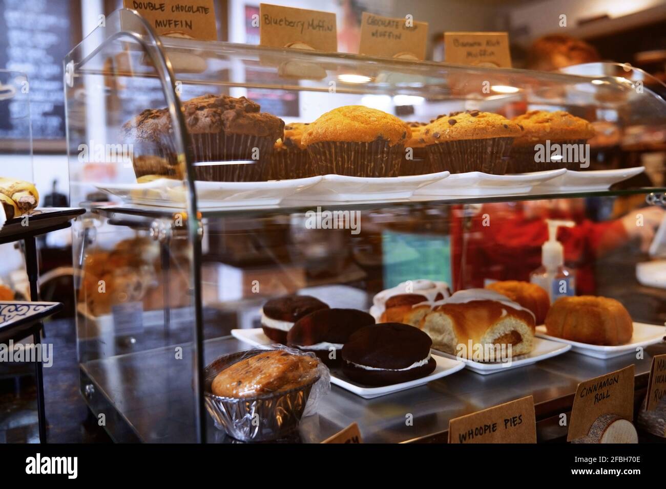 Cakes and muffins displayed inside bakery Stock Photo - Alamy