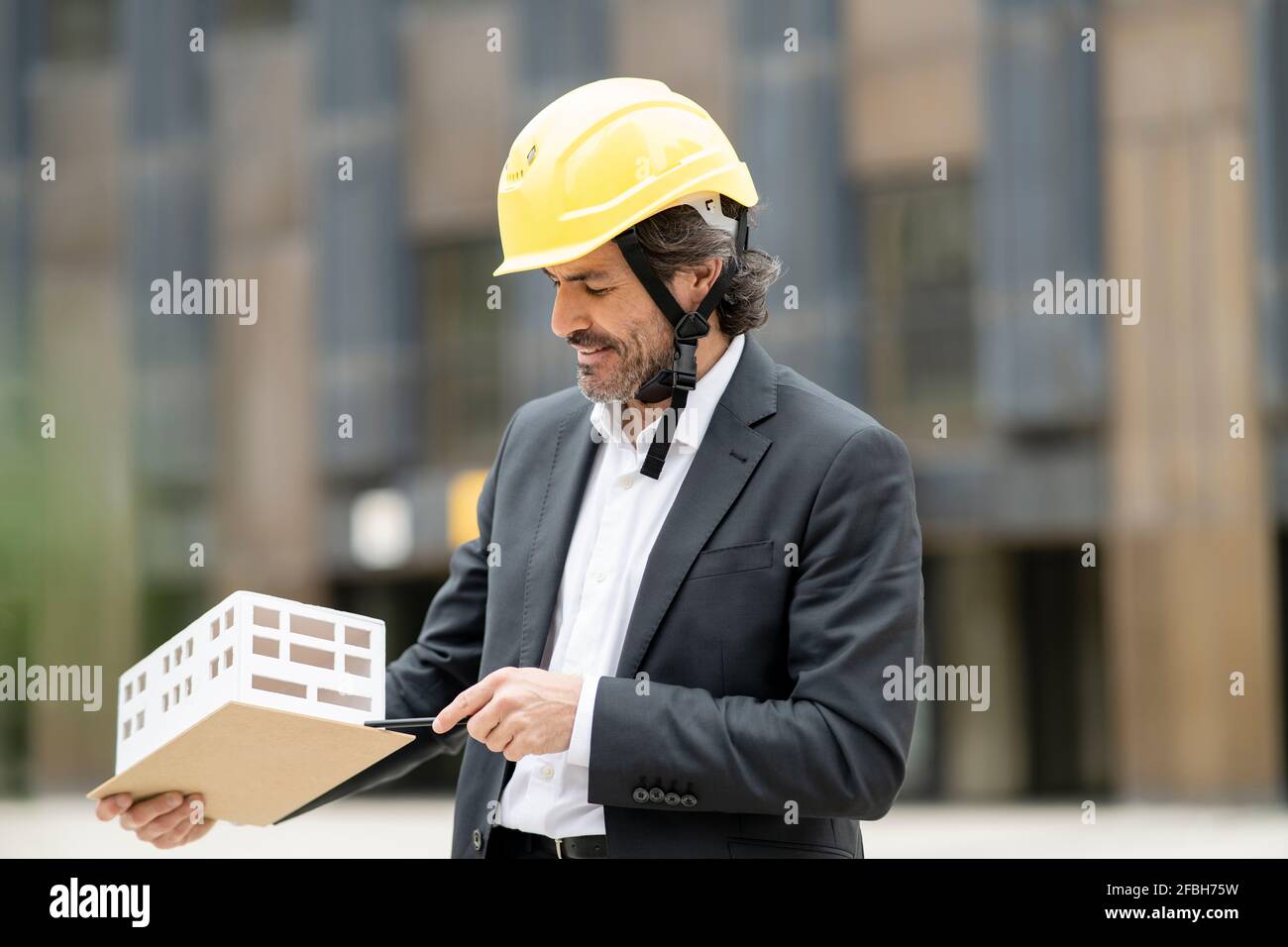 Male architect looking at architectural model Stock Photo - Alamy