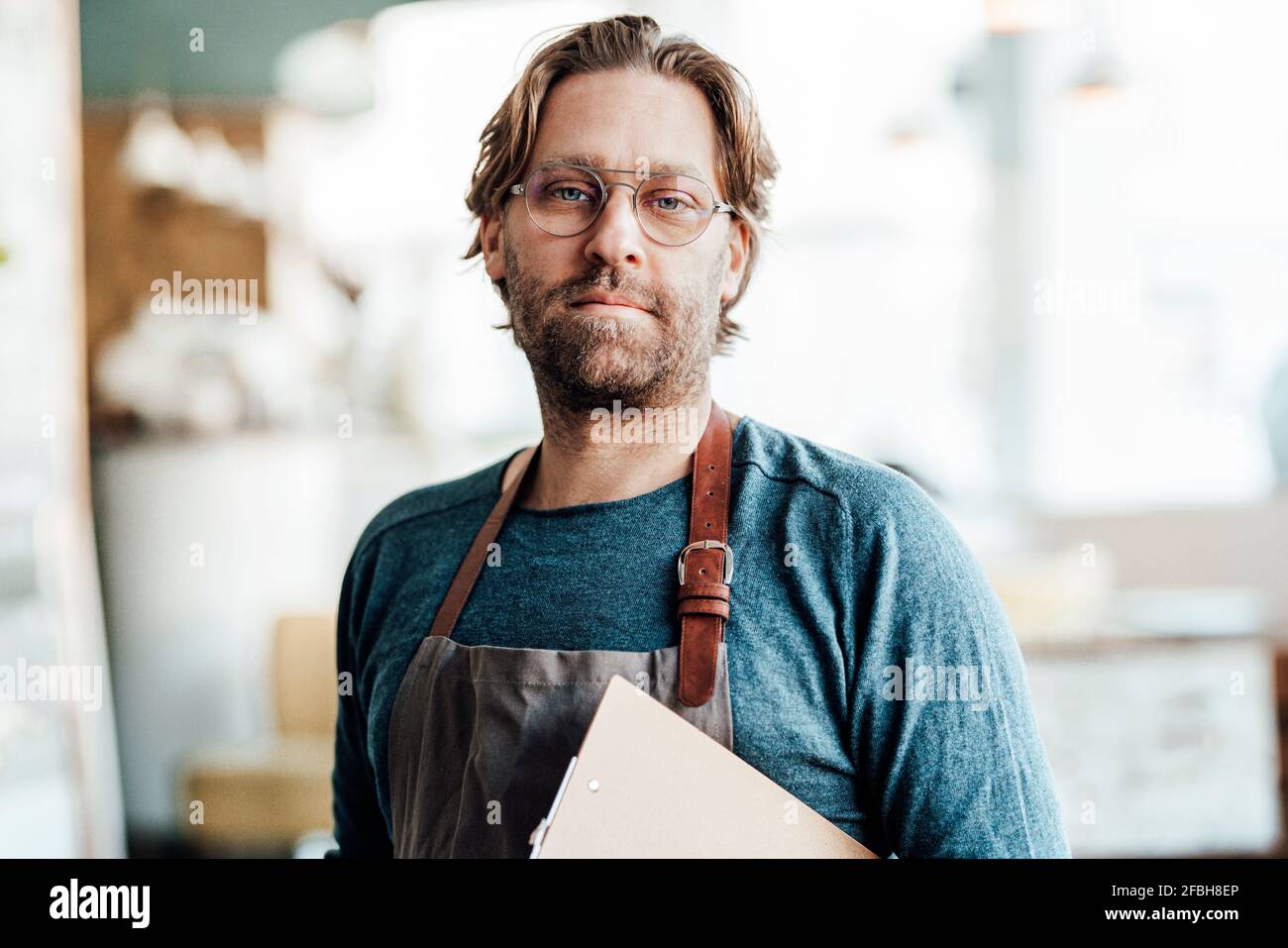 Mature male owner with clipboard at coffee shop Stock Photo - Alamy