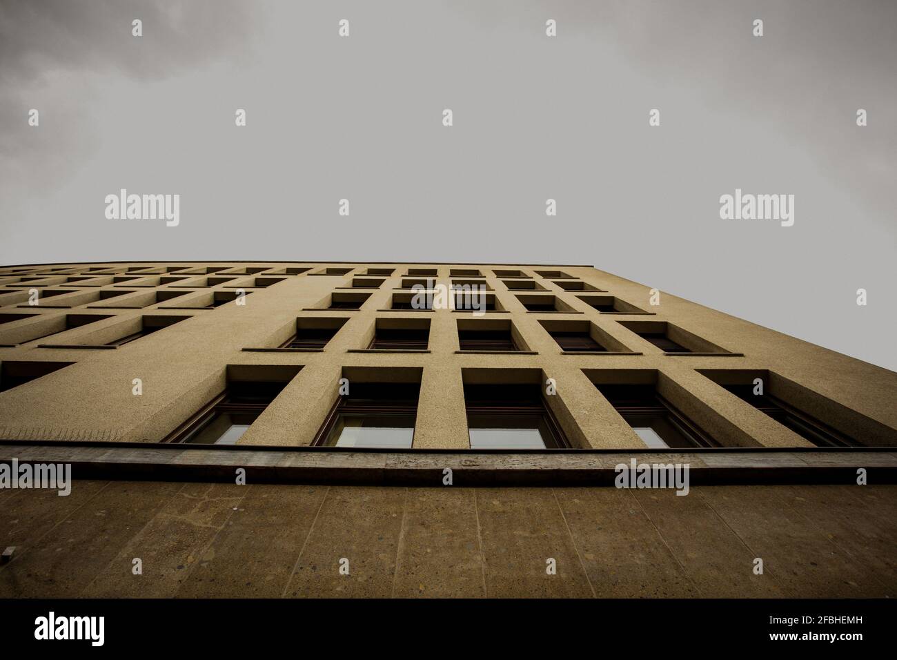 Low angle of a beige building with windows Stock Photo - Alamy