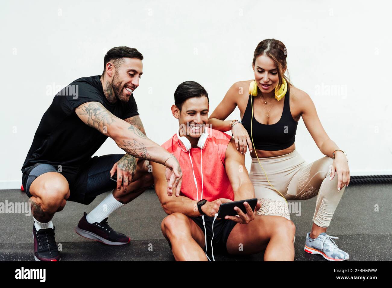 Smiling male and female athletes using mobile phone in gym Stock Photo ...
