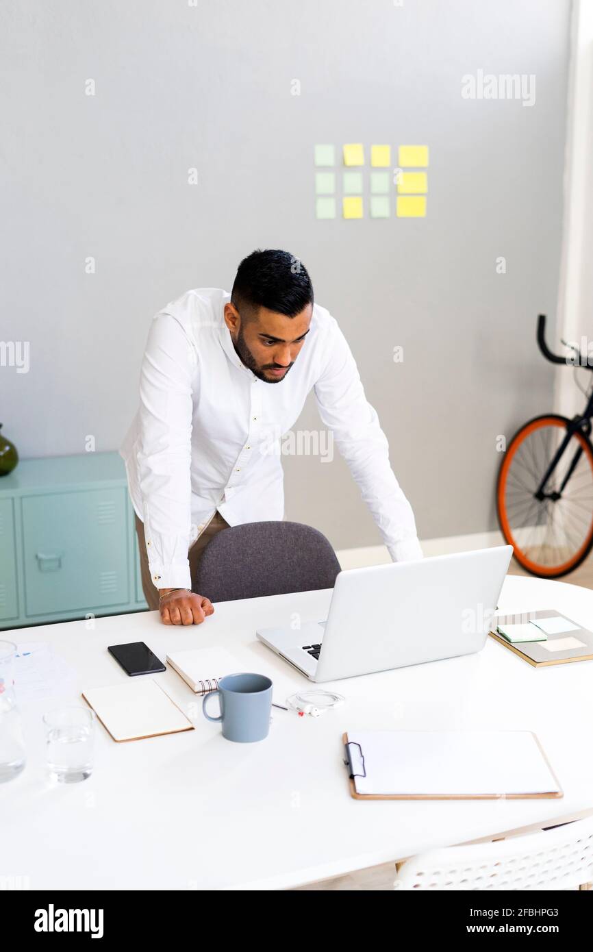 Businessman looking at laptop at office desk hi-res stock photography ...
